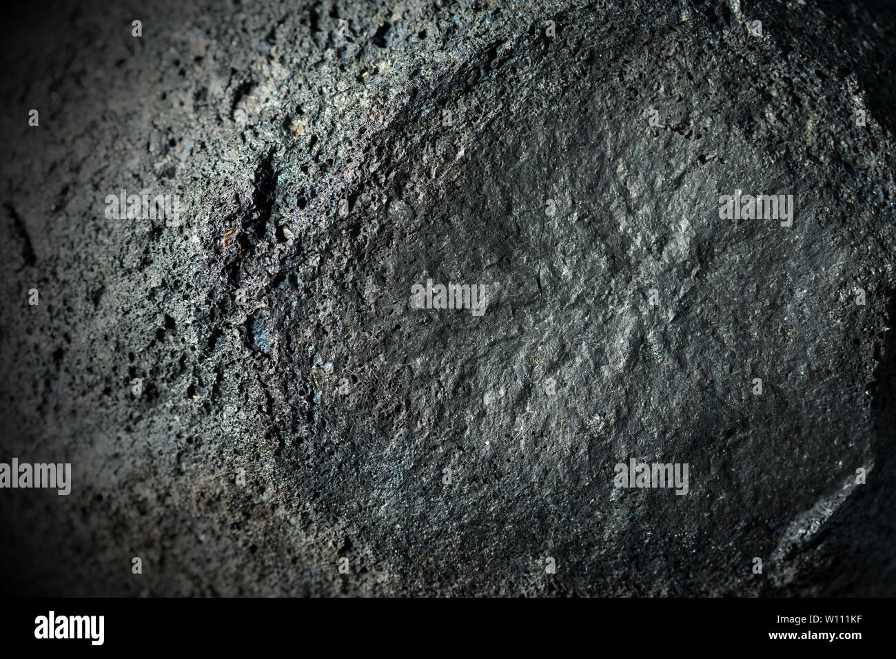 Macro photo of a black volcanic rock (volcanic bomb). Etna volcano ...