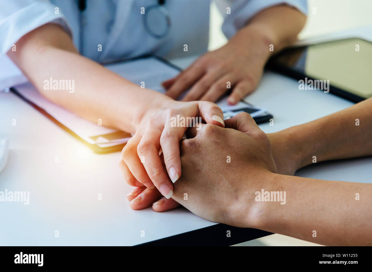 Female doctor holding patient hand hi-res stock photography and images ...