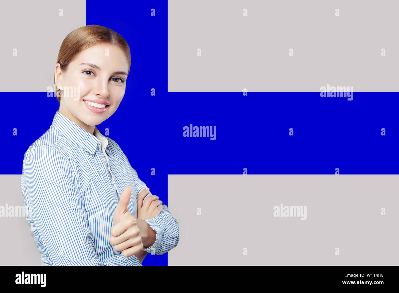 Finland. Young happy cute girl with thumb up against the Finnish flag ...