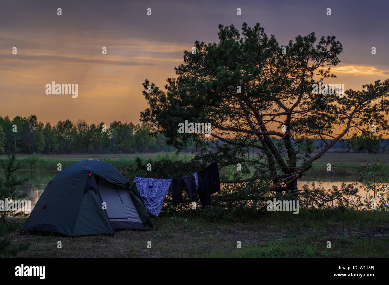 Tourist tent by the river. Life in the tourist camp. Tourist tent on ...