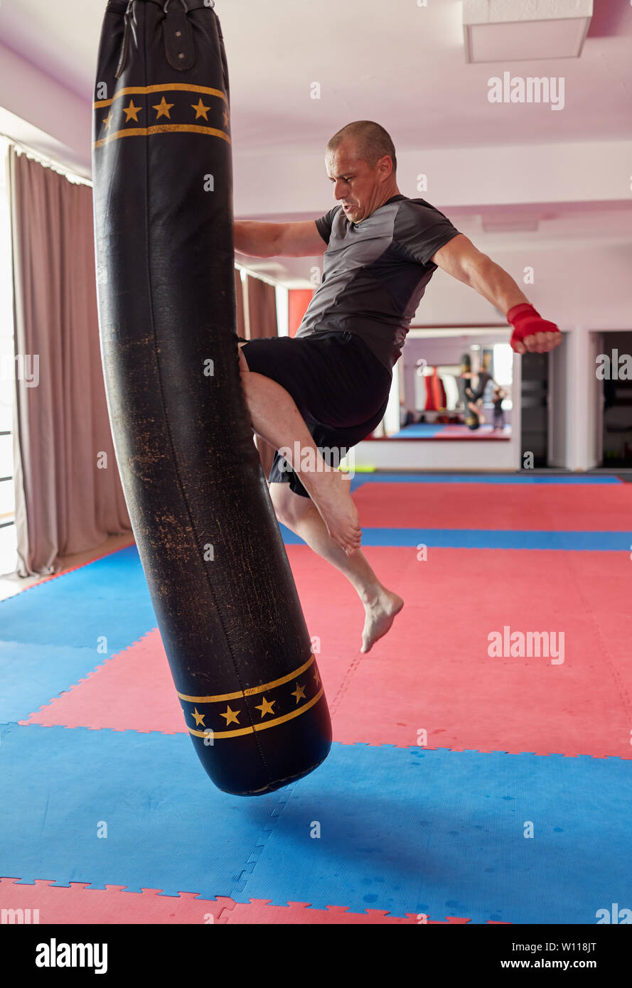 Muay thai fighter kicking the heavy bag Stock Photo - Alamy