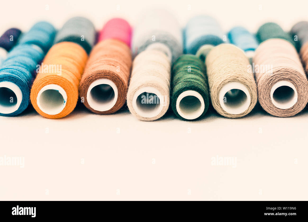 Colored sewing thread coils on white background with copy space for ...