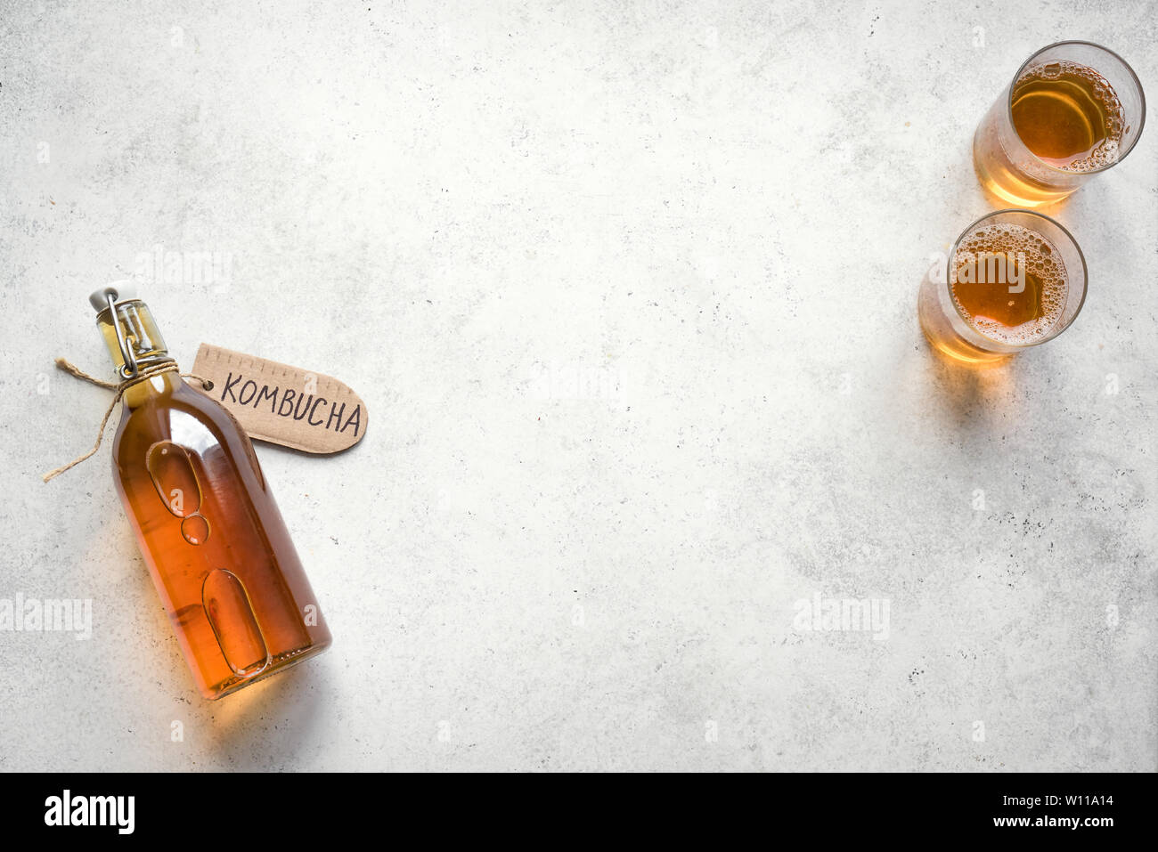 Kombucha fermented drink in glass and bottle on white background, copy ...