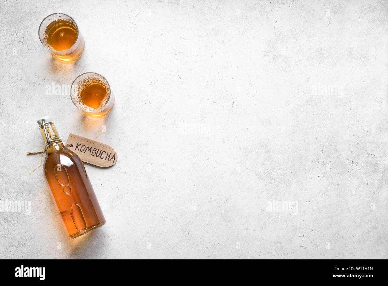 Kombucha fermented drink in glass and bottle on white background, copy ...