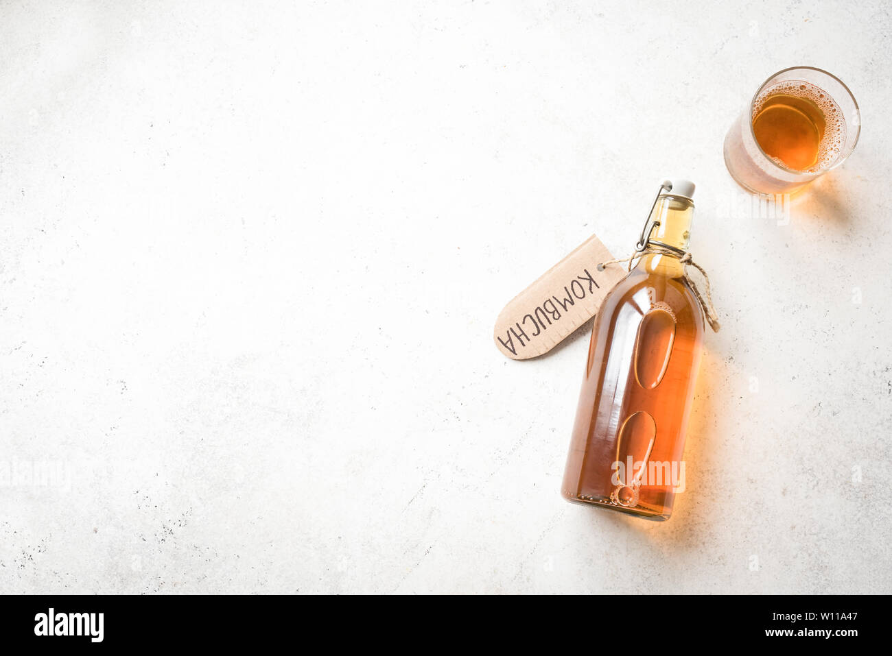 Kombucha fermented drink in glass and bottle on white background, copy ...