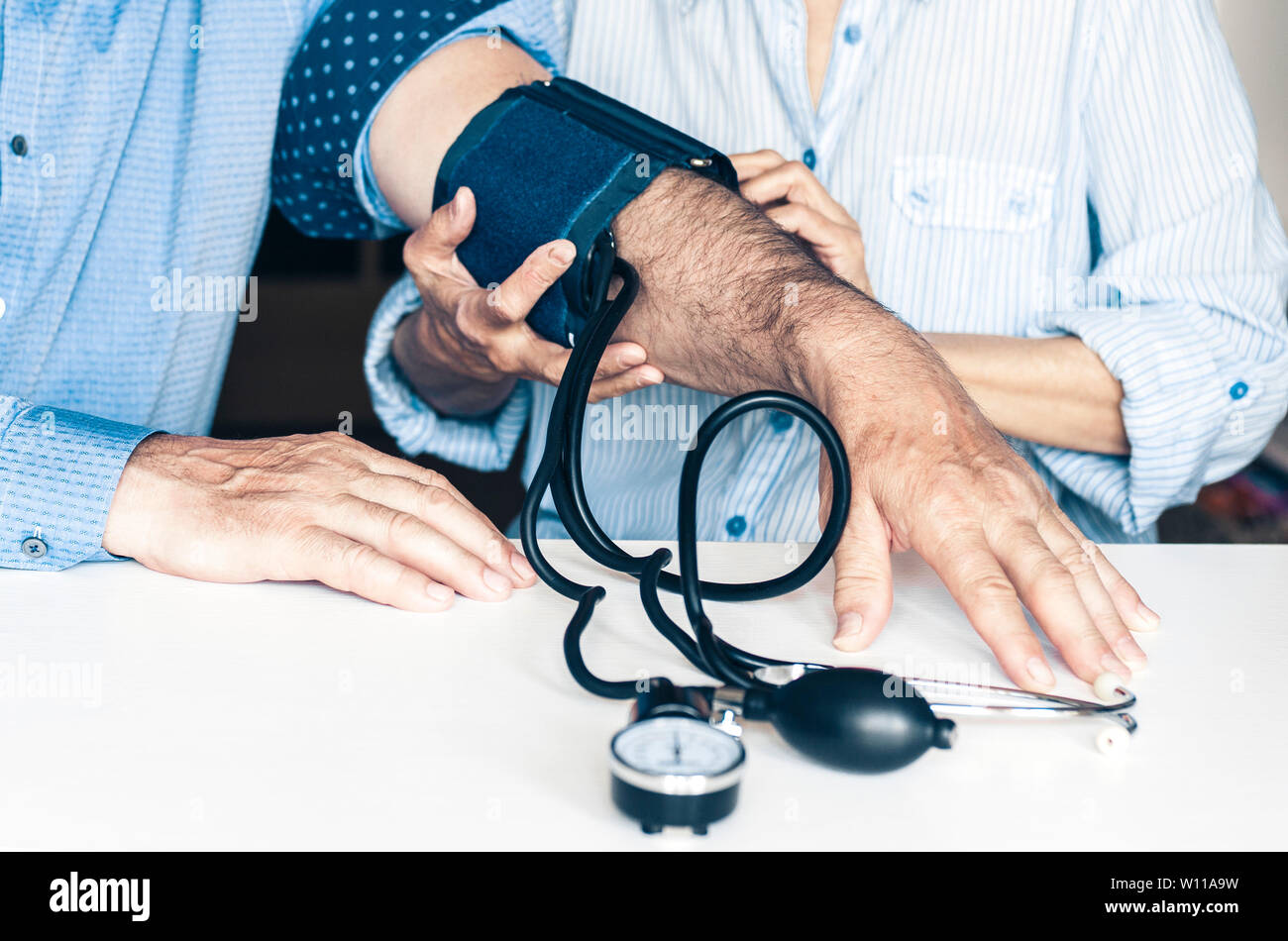 The therapist female hands with a classic tonometer measuring blood ...