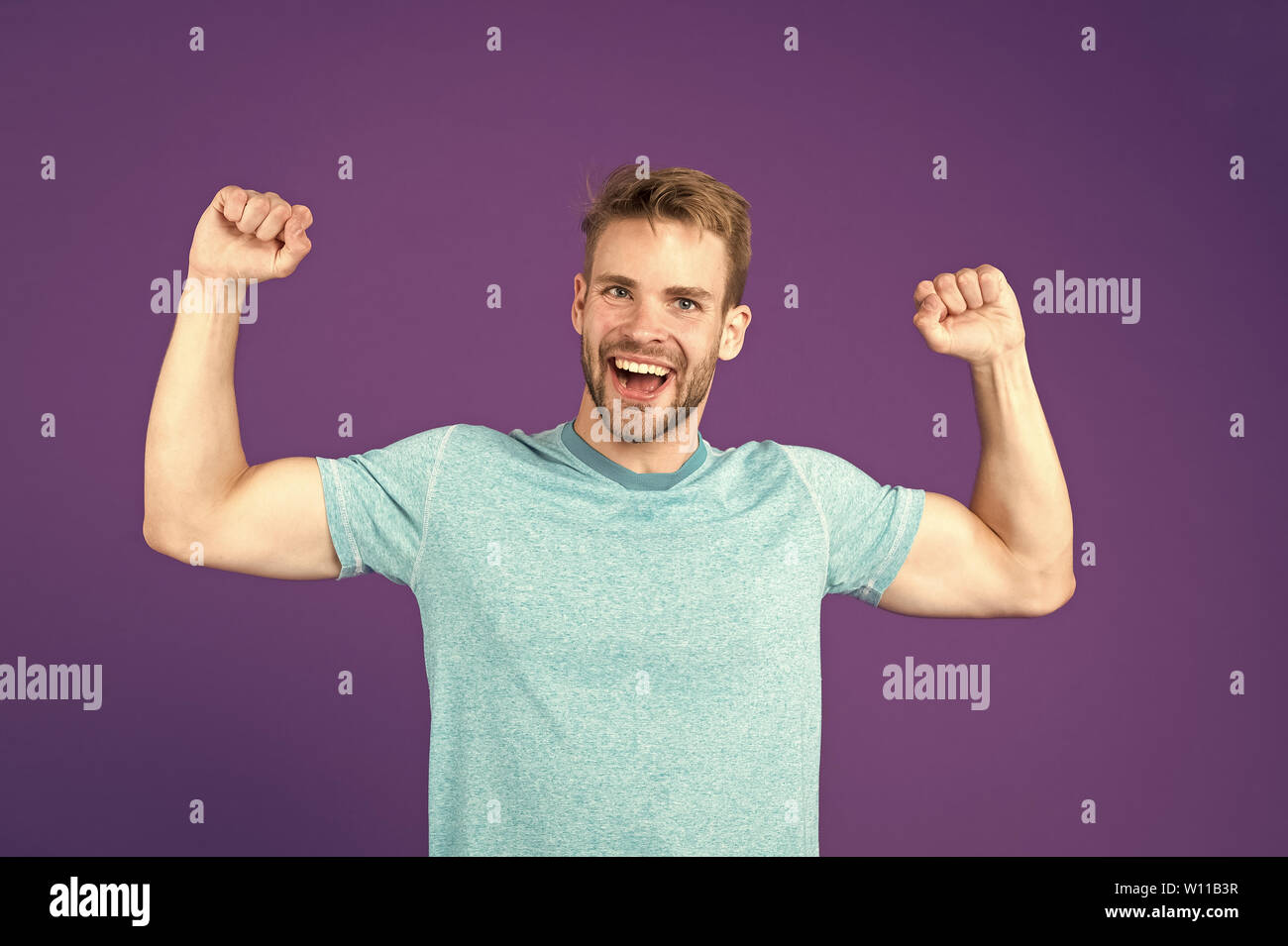 Strong and full of energy. Man strong handsome unshaven guy on violet ...