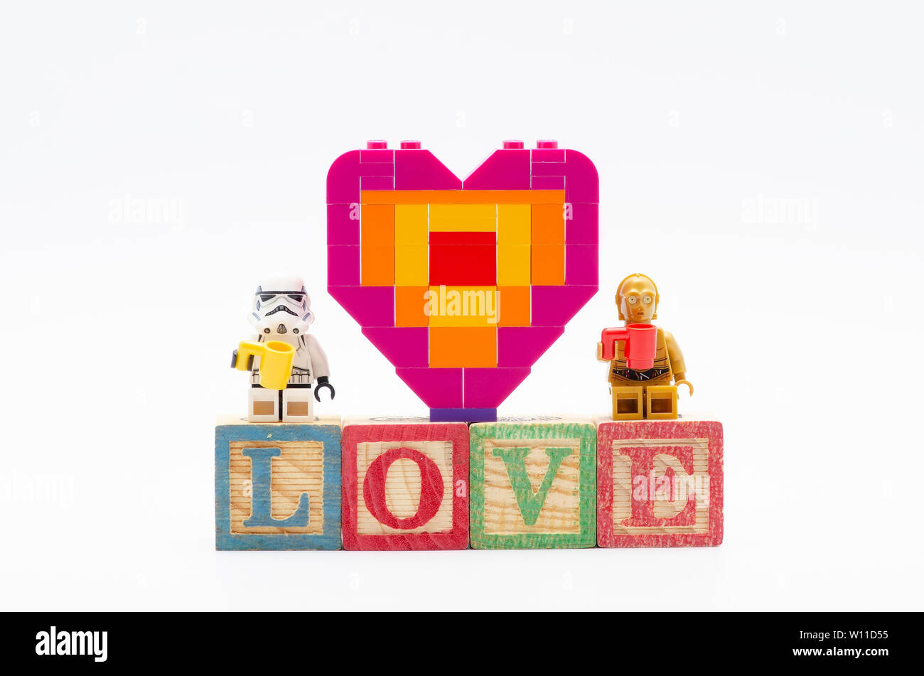 lego stormtrooper sitting on word love with piece offering heart shape ...