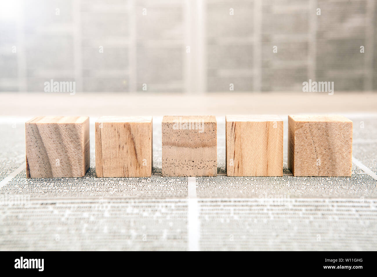 Five wooden cube blocks on a newspaper background closeup Stock Photo ...