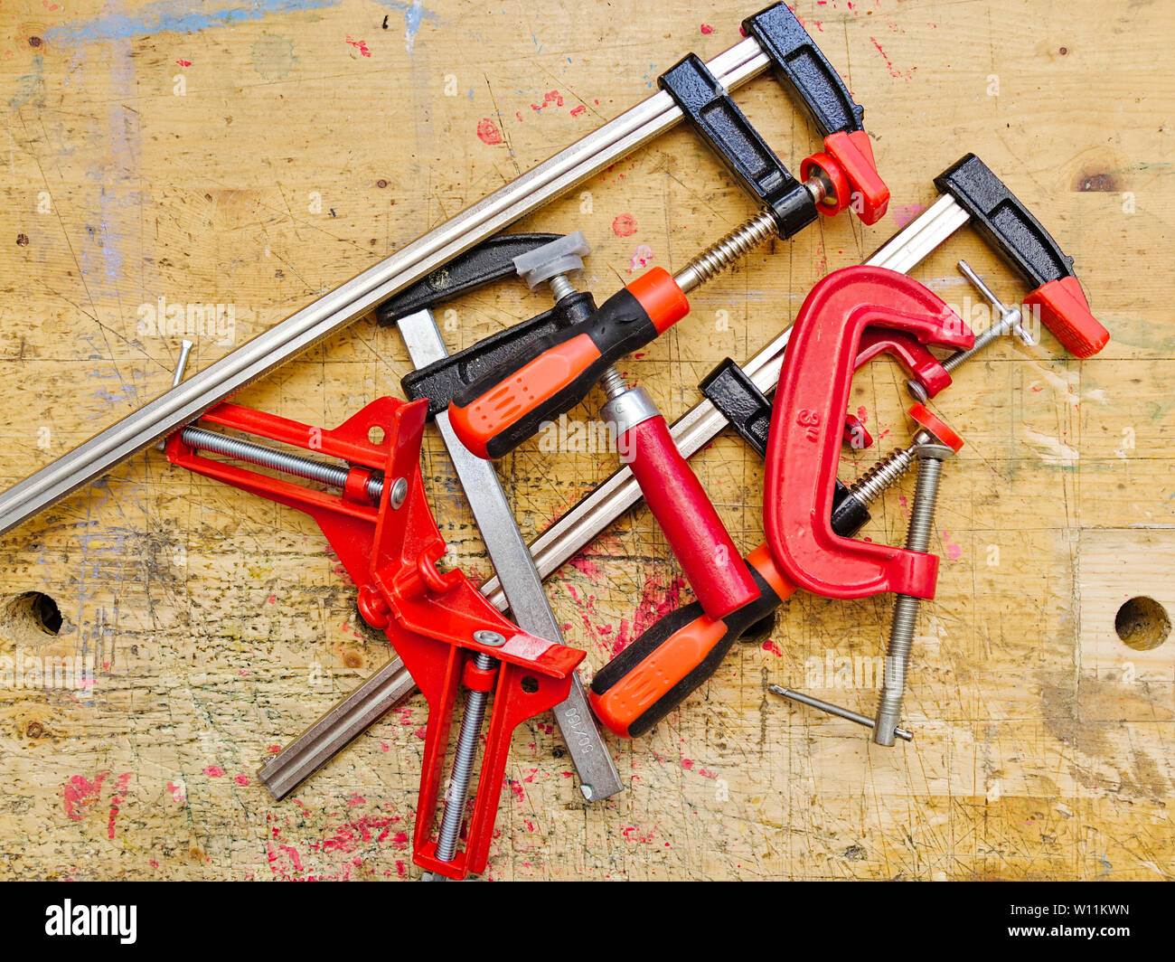Various assorted metal clamps on wooden workbench surface Stock Photo ...