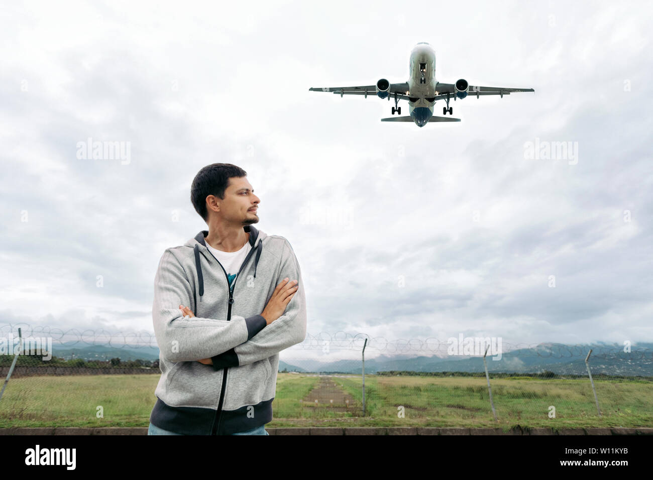 traveler man stands and looks the airplane taking off Stock Photo - Alamy