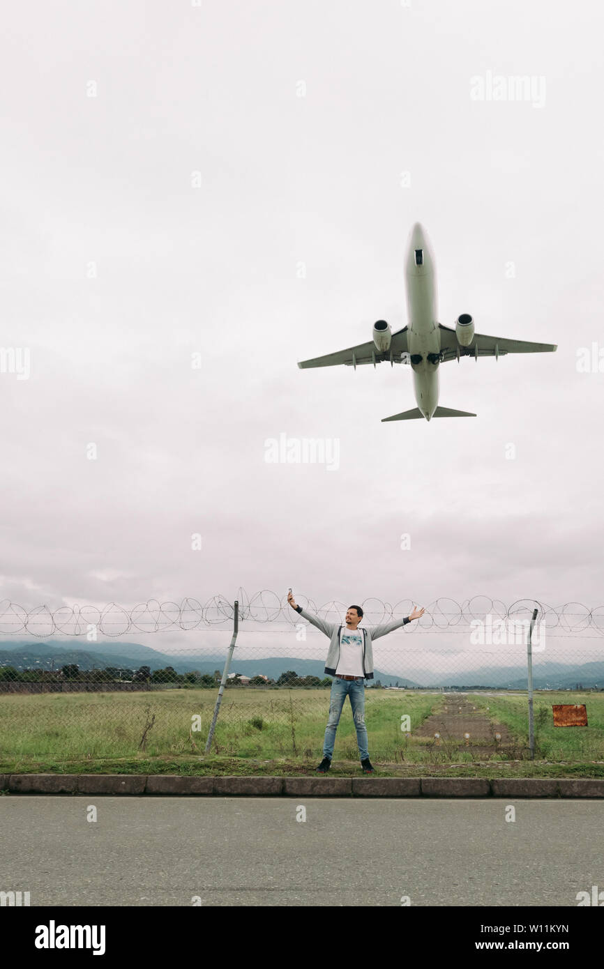 traveler man stands and looks the airplane taking off Stock Photo - Alamy