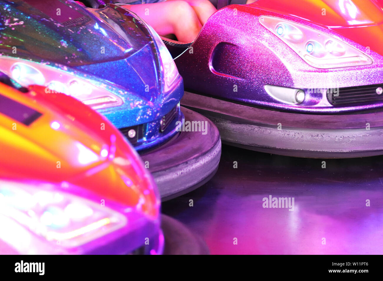 close-up of multi colored bumper cars at a fair, background with copy ...