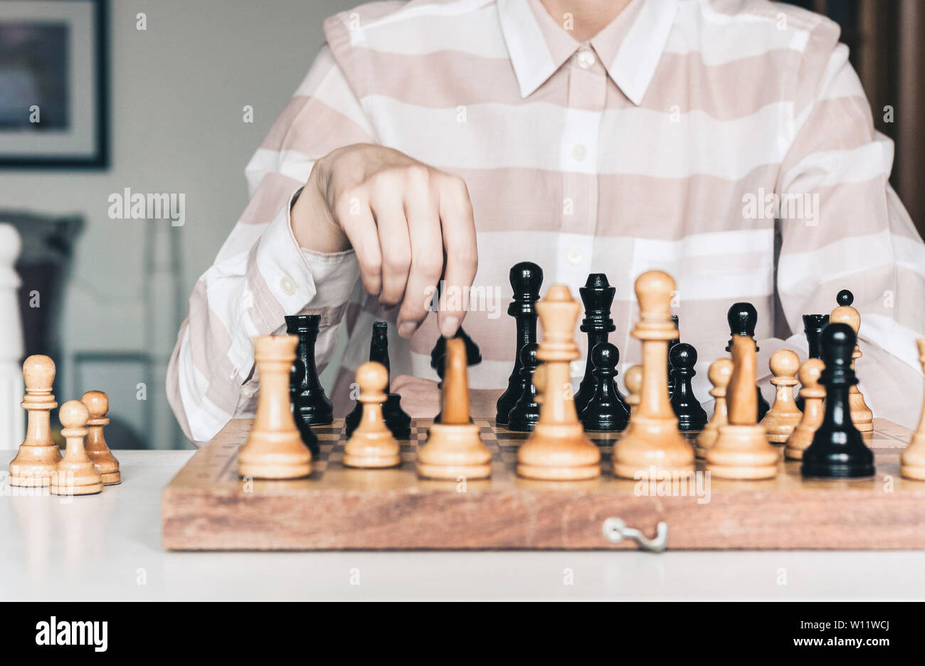 Wooden chess pieces on a chessboard, chess game woman player makes a ...