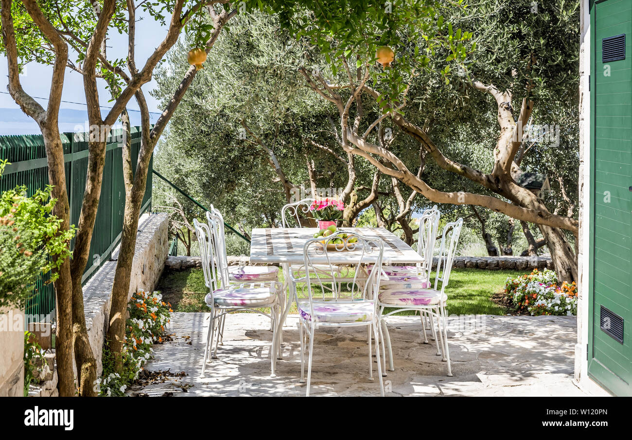 Beautiful garden, table setting prepared for a meal and view on ...
