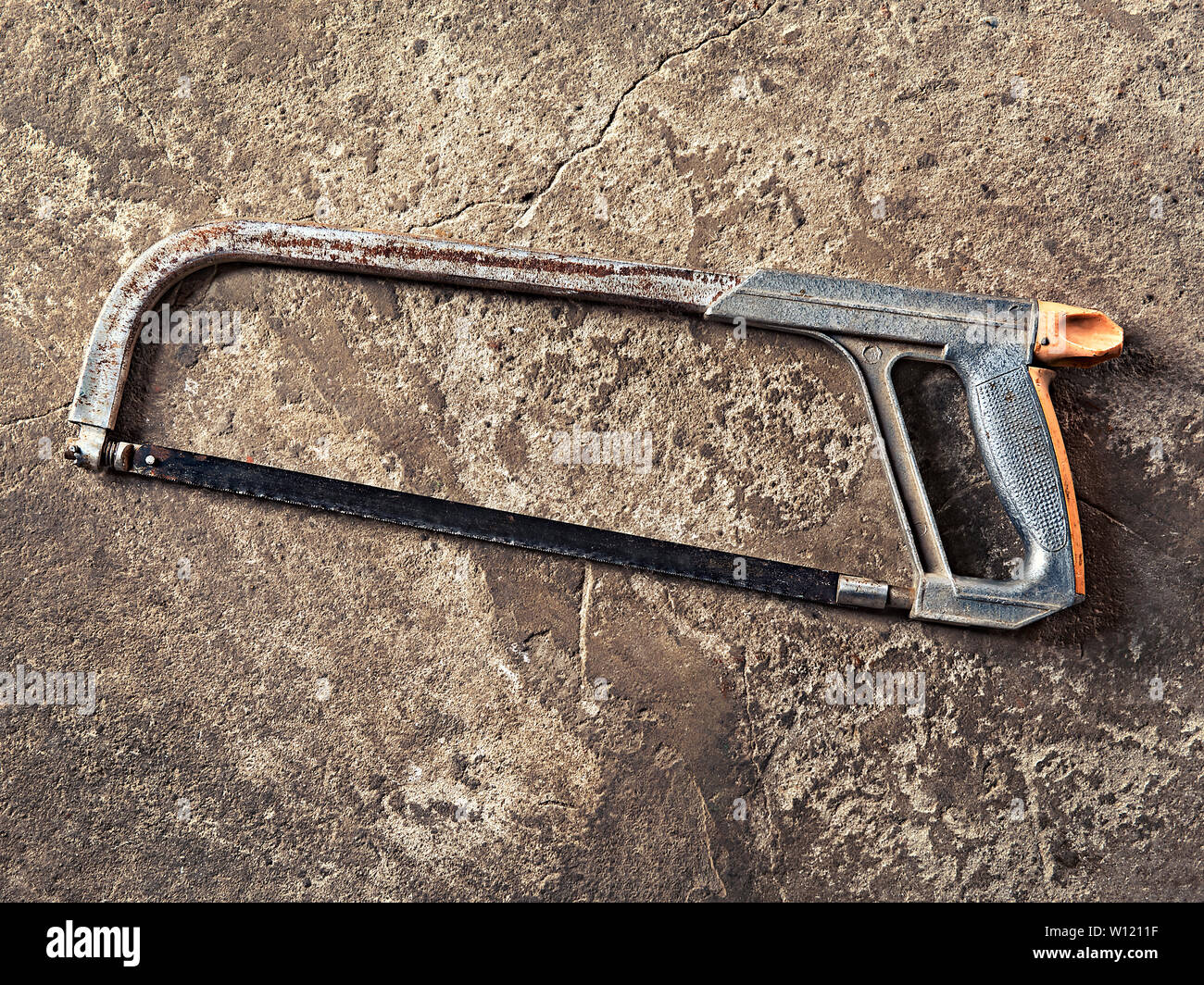 old hacksaw on concrete grungy background Stock Photo - Alamy