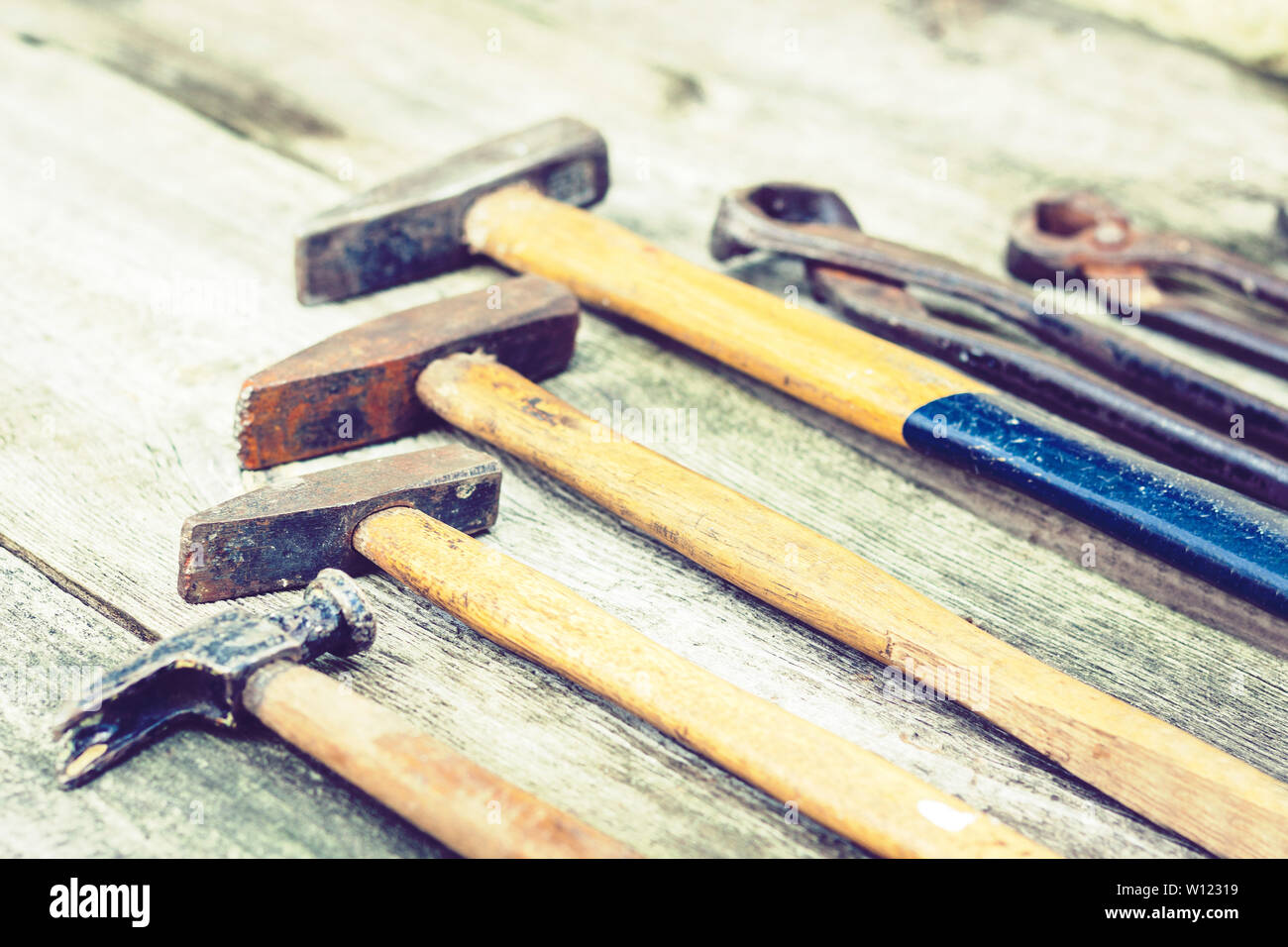 Set of vintage hand construction tools hammers on a wooden background ...