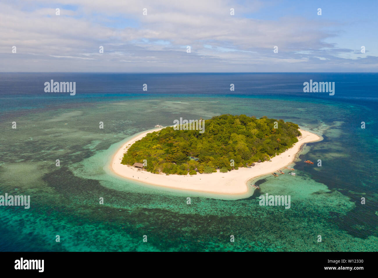 A small island surrounded by azure water and coral reefs, a top view ...
