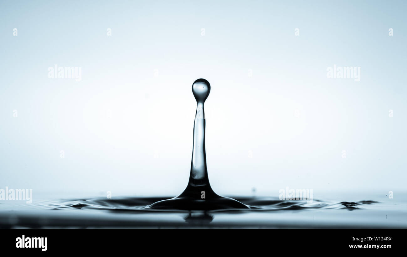 Close-up of a water drop falling on water surface Stock Photo - Alamy