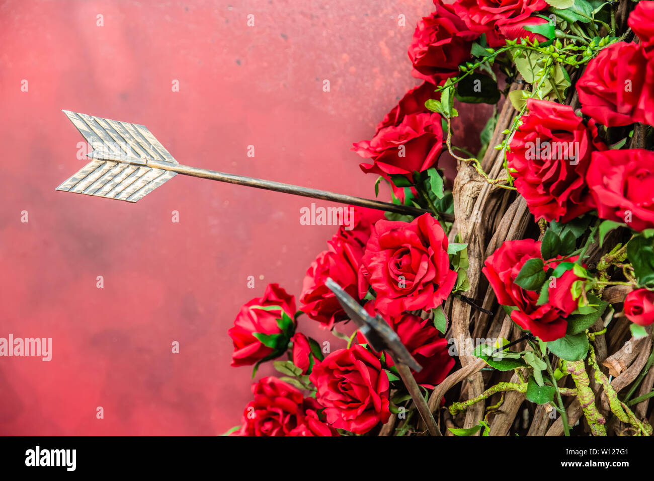 rose wreath and arrow on red background Stock Photo - Alamy