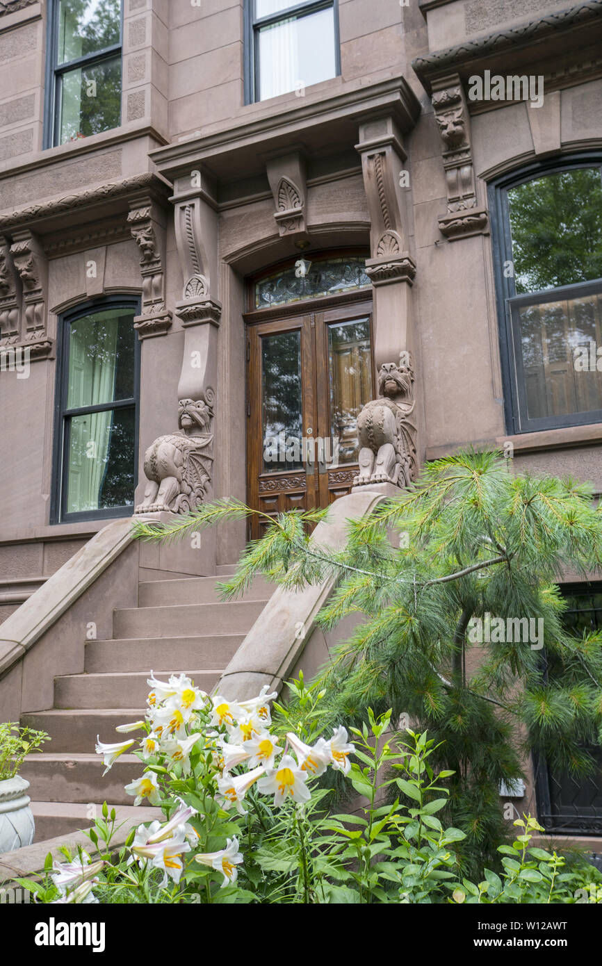 Steps at a high stoop brownstone building with protective gargoyles at ...