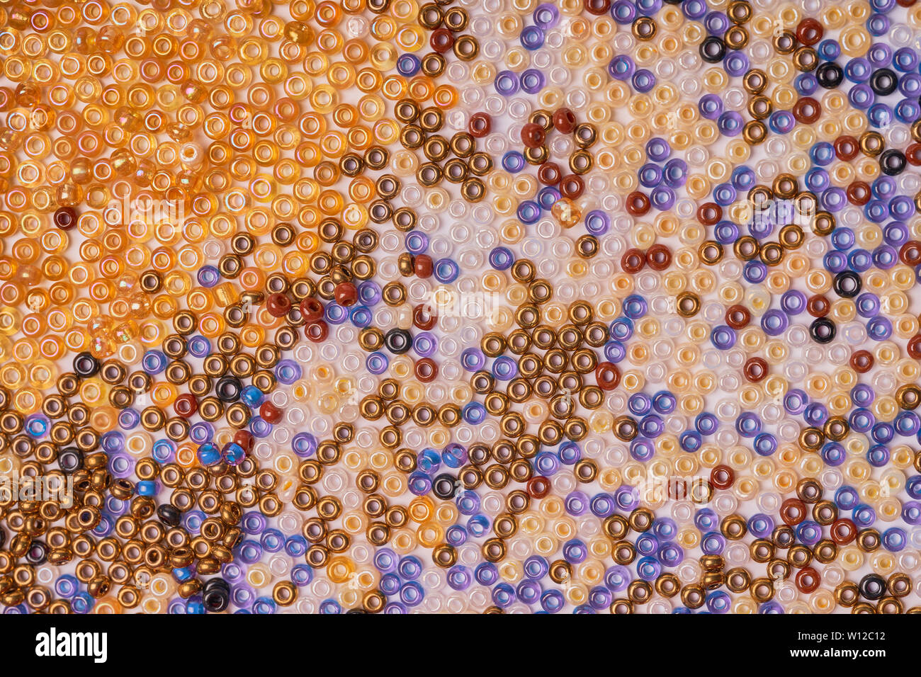 Multi-colored glass seed beads on a white background Stock Photo - Alamy