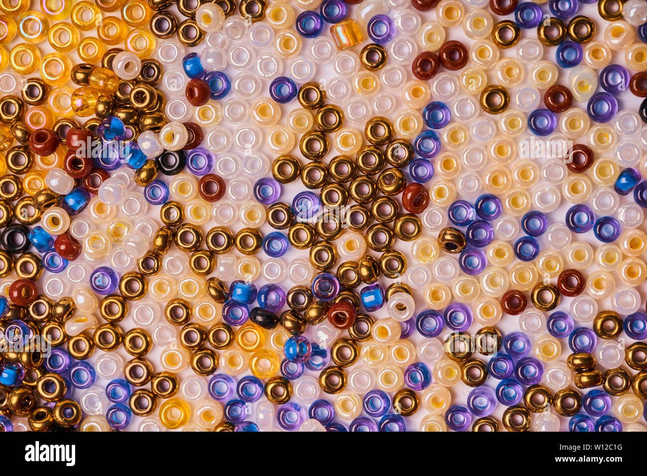 Multi-colored glass seed beads on a white background Stock Photo - Alamy