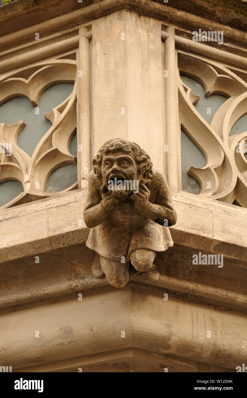 gargoyle with tongue hanging out of mouth at balcony of medieval town ...