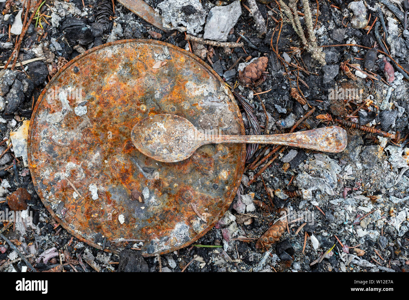 Rusty spoon and metal plate on the ground after a fire Stock Photo - Alamy