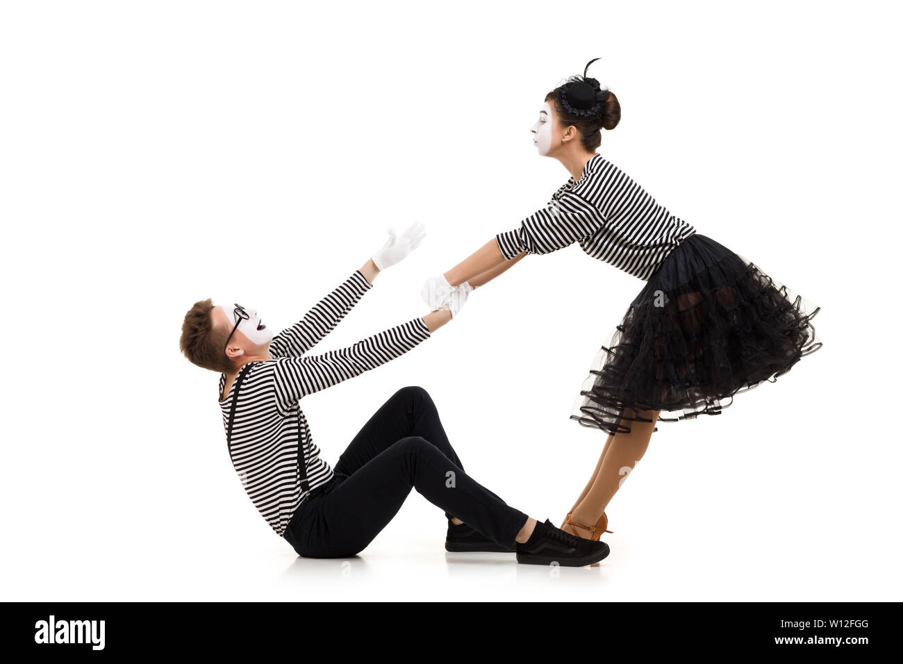 Smiling mimes in striped shirts. Man and woman dressed as actors of ...