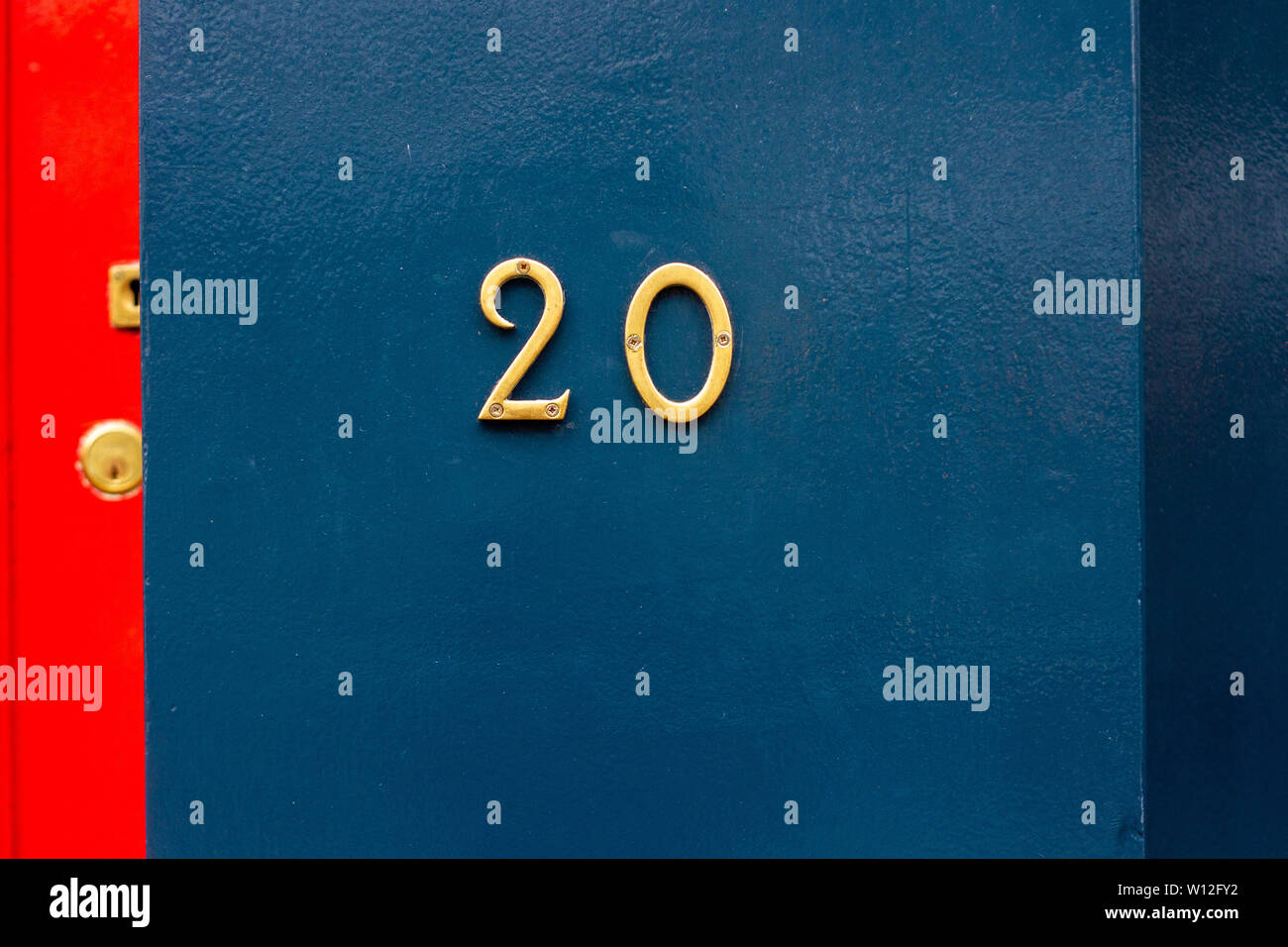 House number 20 in bronze on blue before red Stock Photo - Alamy