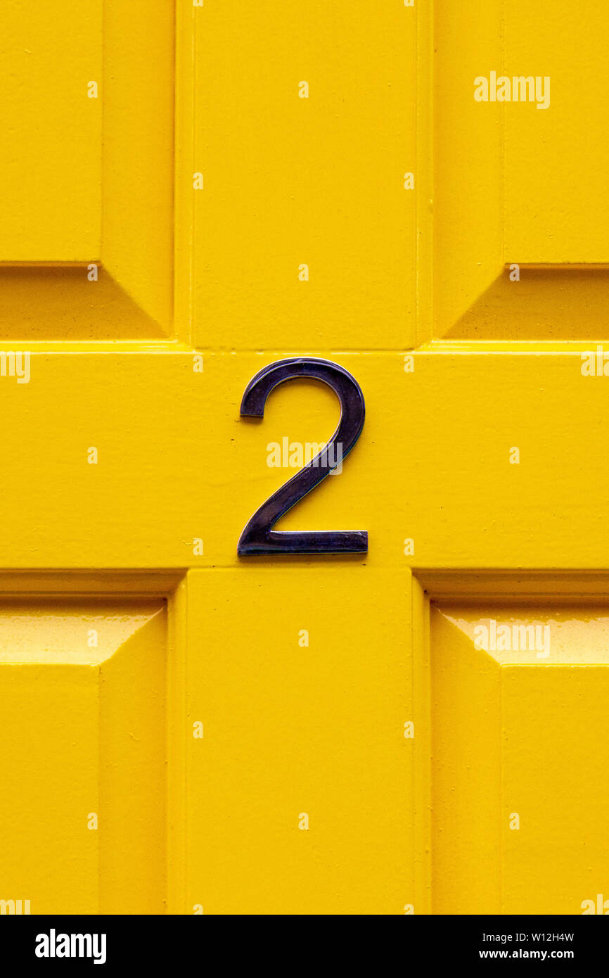 House number 2 with the two centred on a bright yellow front door Stock ...