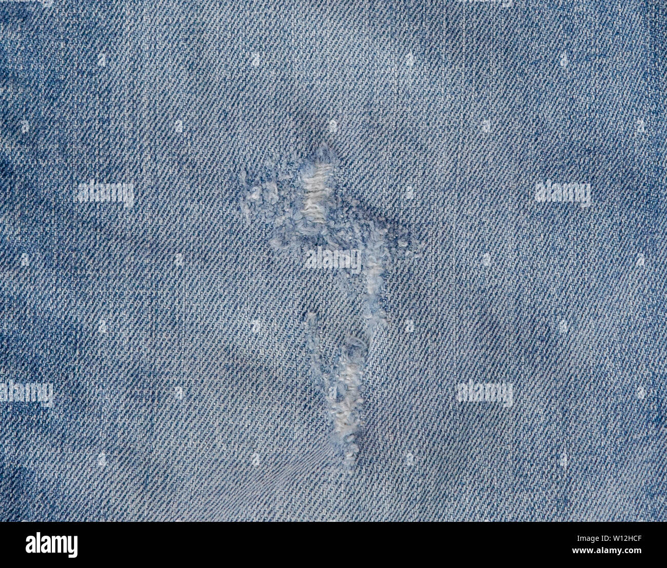 Hole and Threads on Denim Jeans. Ripped Destroyed Torn Blue jeans ...
