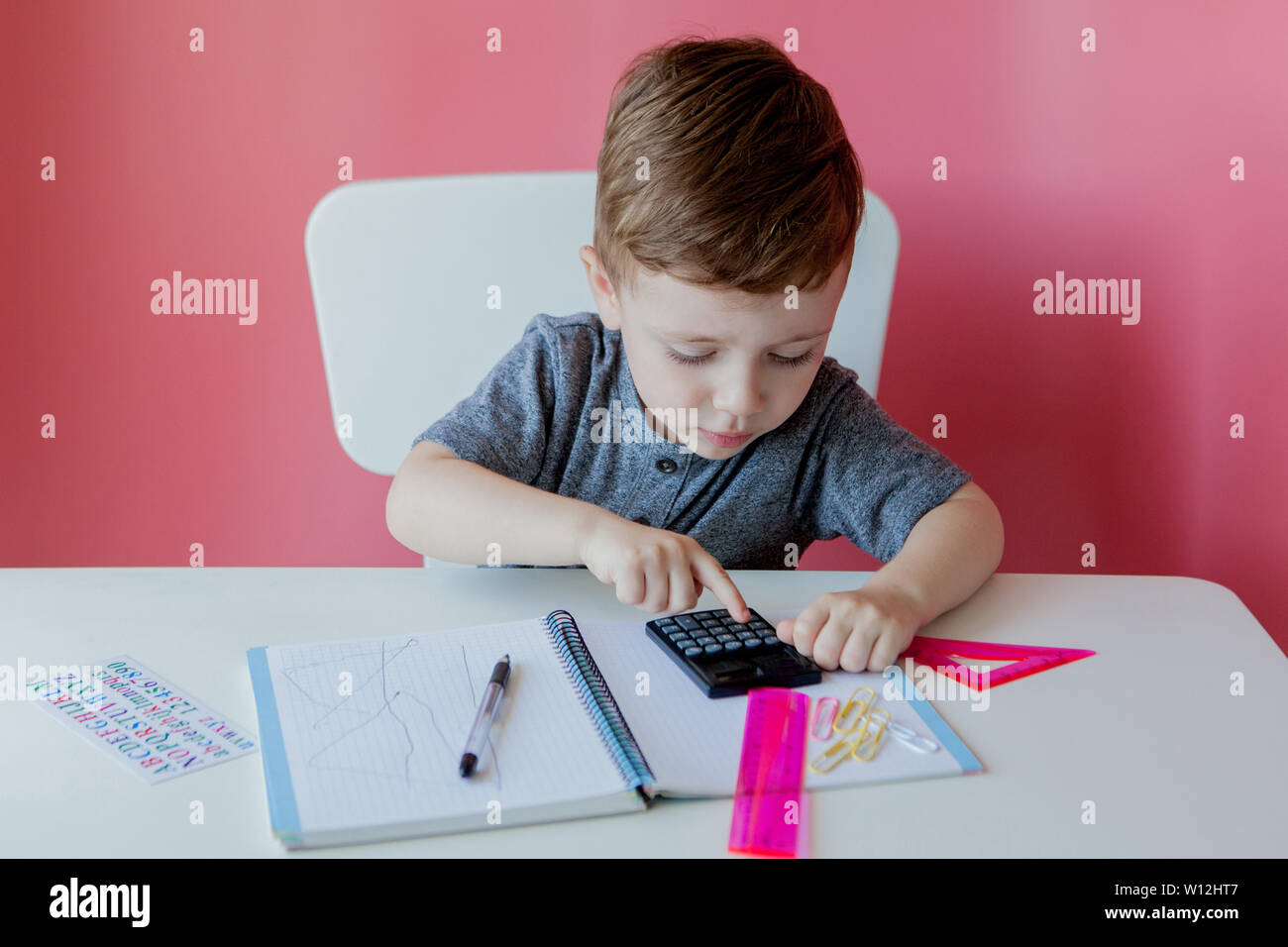 Portrait of cute kid boy at home making homework. Little concentrated ...