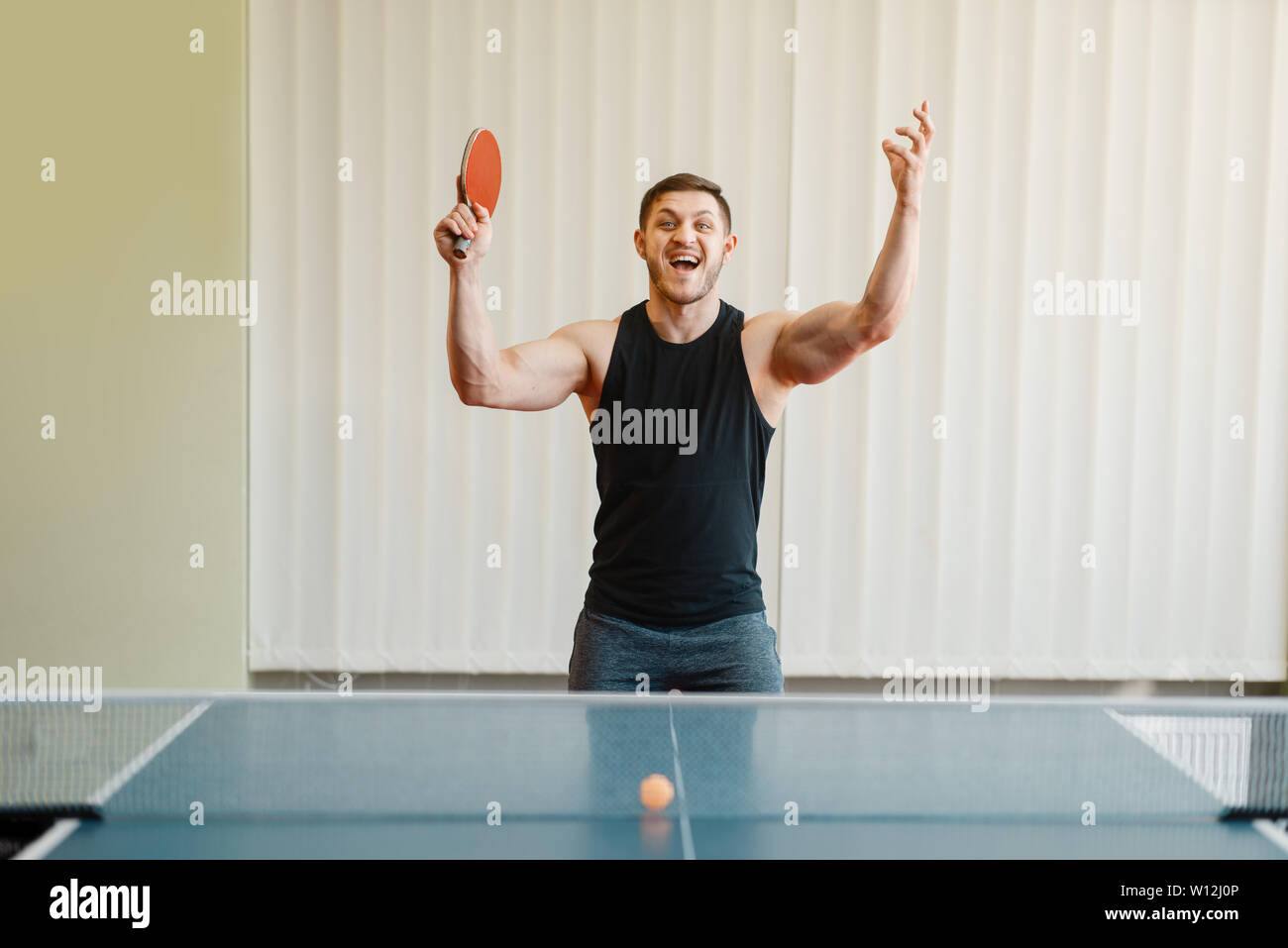 Man with racket in hand wins ping pong tournament Stock Photo - Alamy