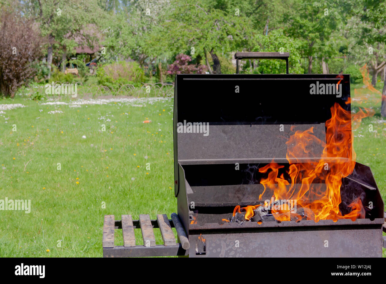Barbecue grill with fire in the garden outdoor closeup view Stock Photo ...