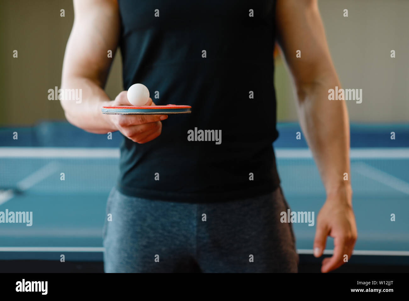 Male person holds racket and ping pong ball on it Stock Photo - Alamy
