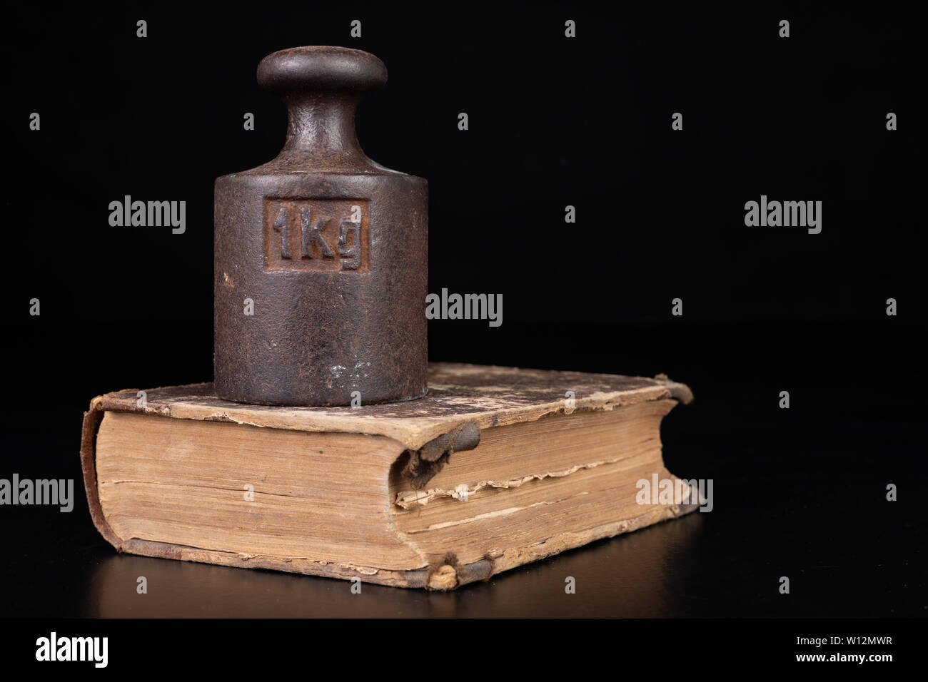 Old kilo weights on books. Old books and weighing machines. Dark ...