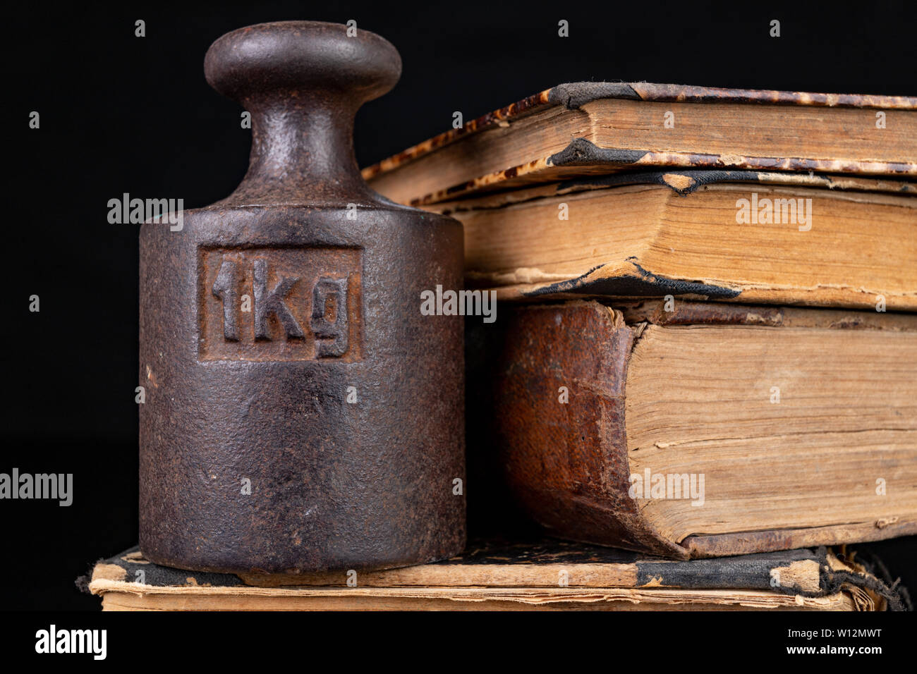 Old kilo weights on books. Old books and weighing machines. Dark ...