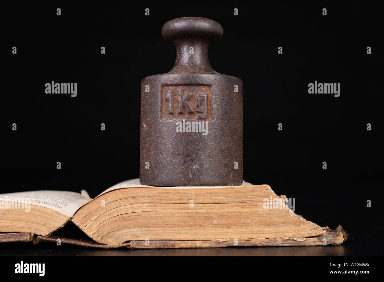 Old kilo weights on books. Old books and weighing machines. Dark ...