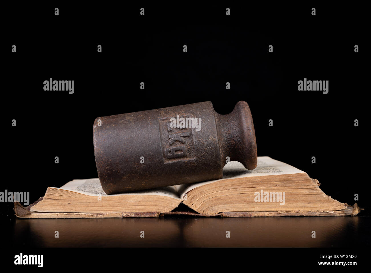 Old kilo weights on books. Old books and weighing machines. Dark ...