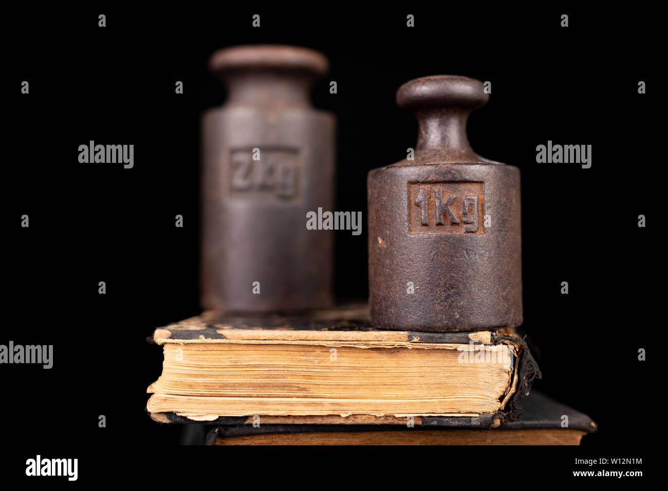 Old kilo weights on books. Old books and weighing machines. Dark ...