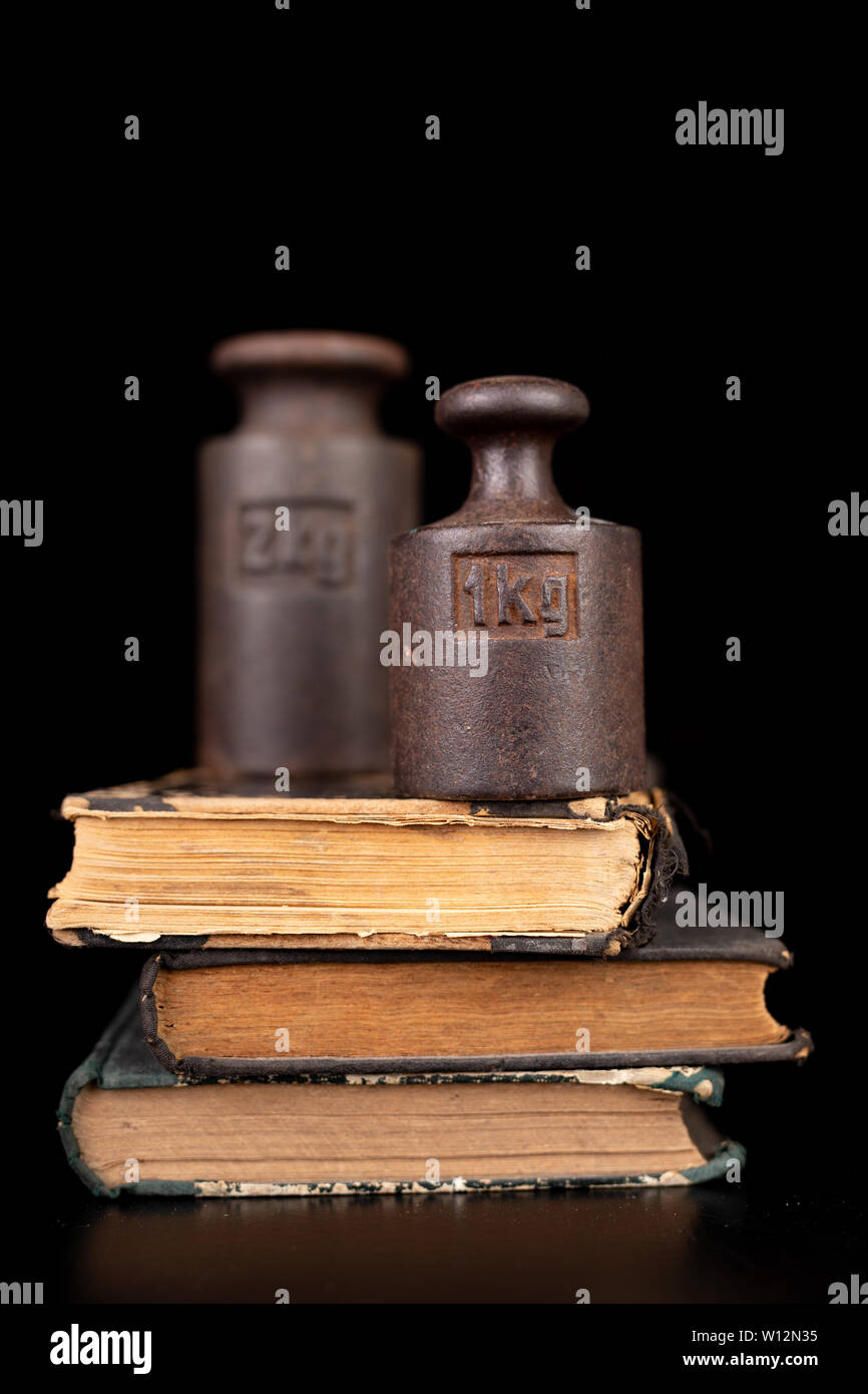 Old kilo weights on books. Old books and weighing machines. Dark ...