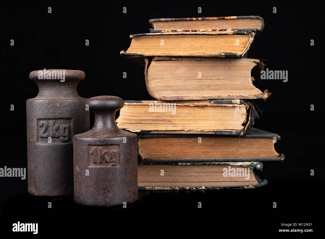 Old kilo weights on books. Old books and weighing machines. Dark ...