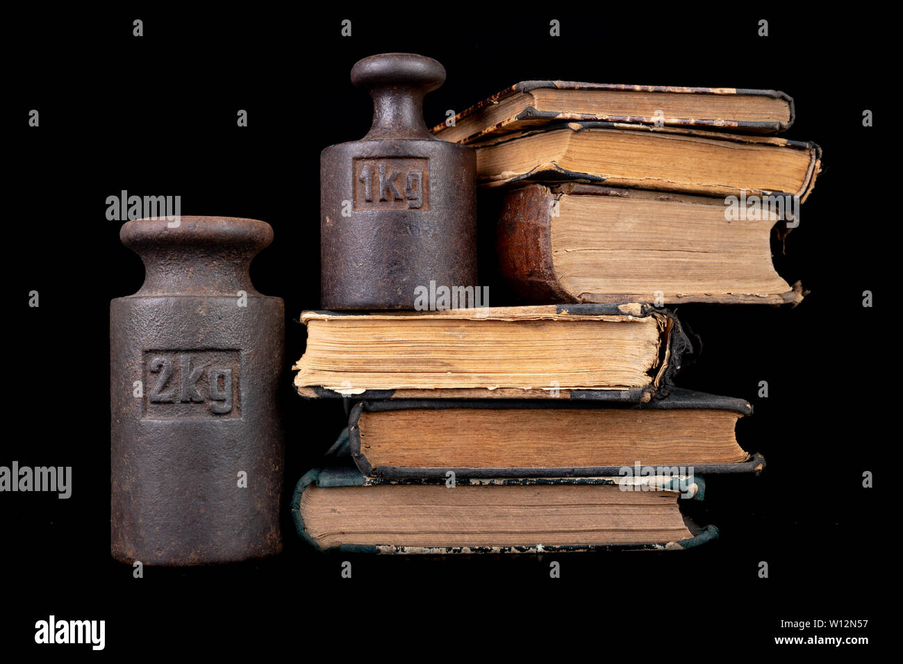 Old kilo weights on books. Old books and weighing machines. Dark ...