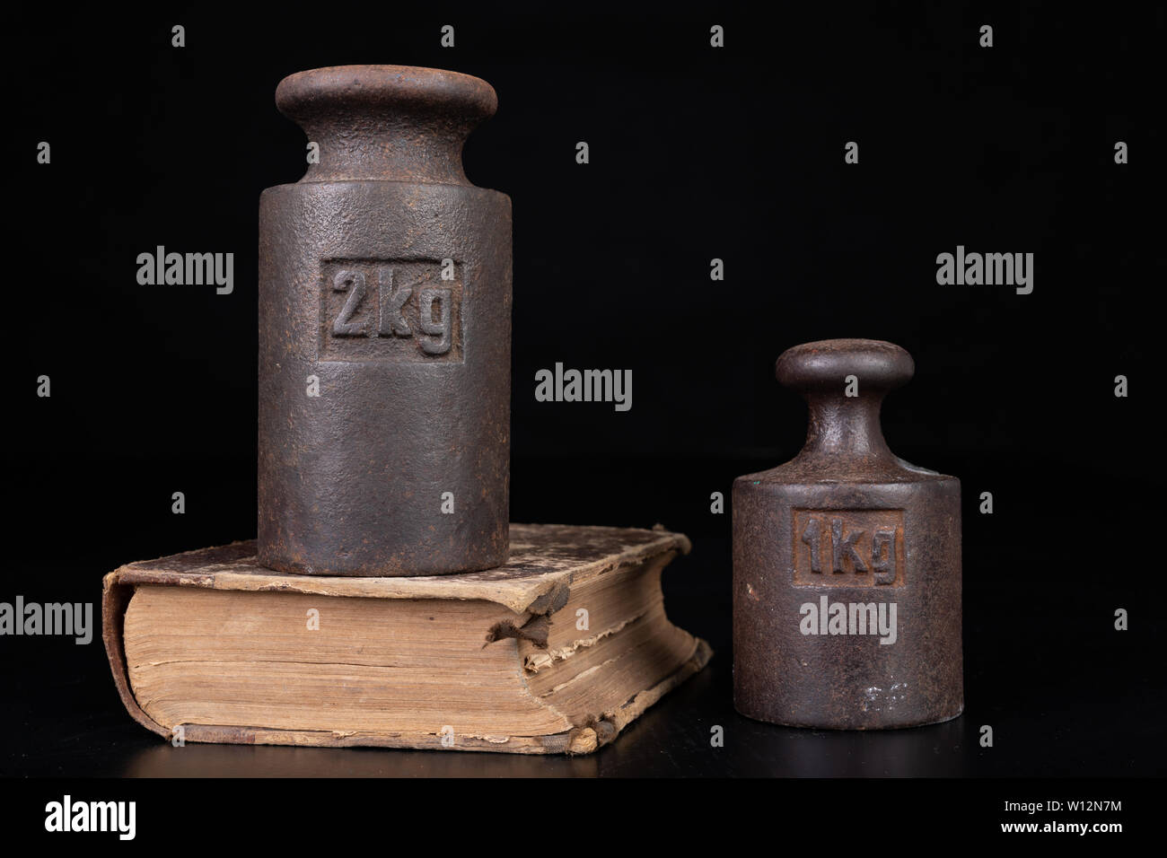 Old kilo weights on books. Old books and weighing machines. Dark ...