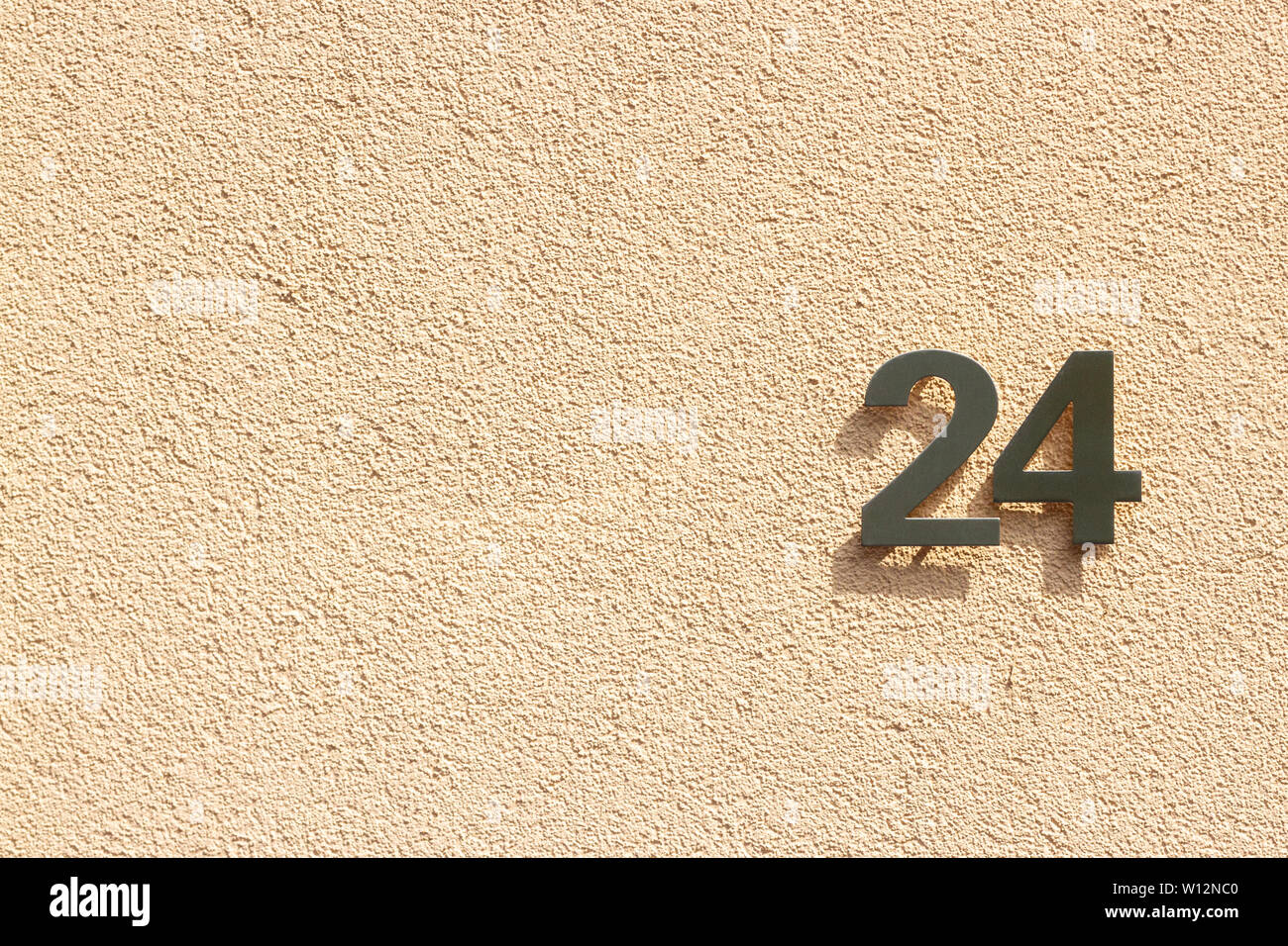 House number 24 with the twenty-four in silver metal digits throwing a ...