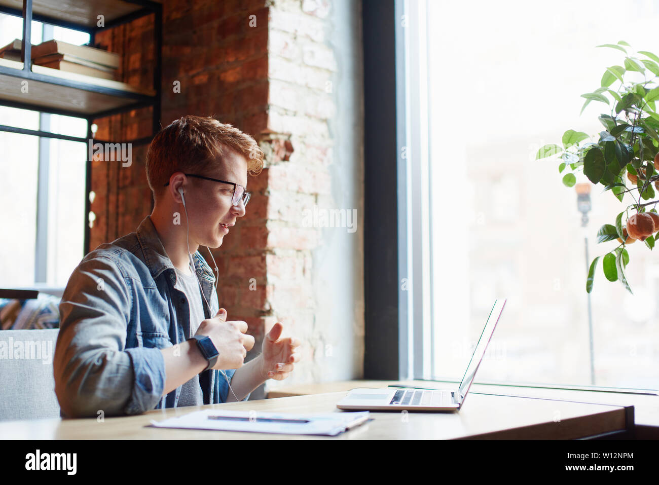 Man in glasses moving hands while having a conversation and working at ...