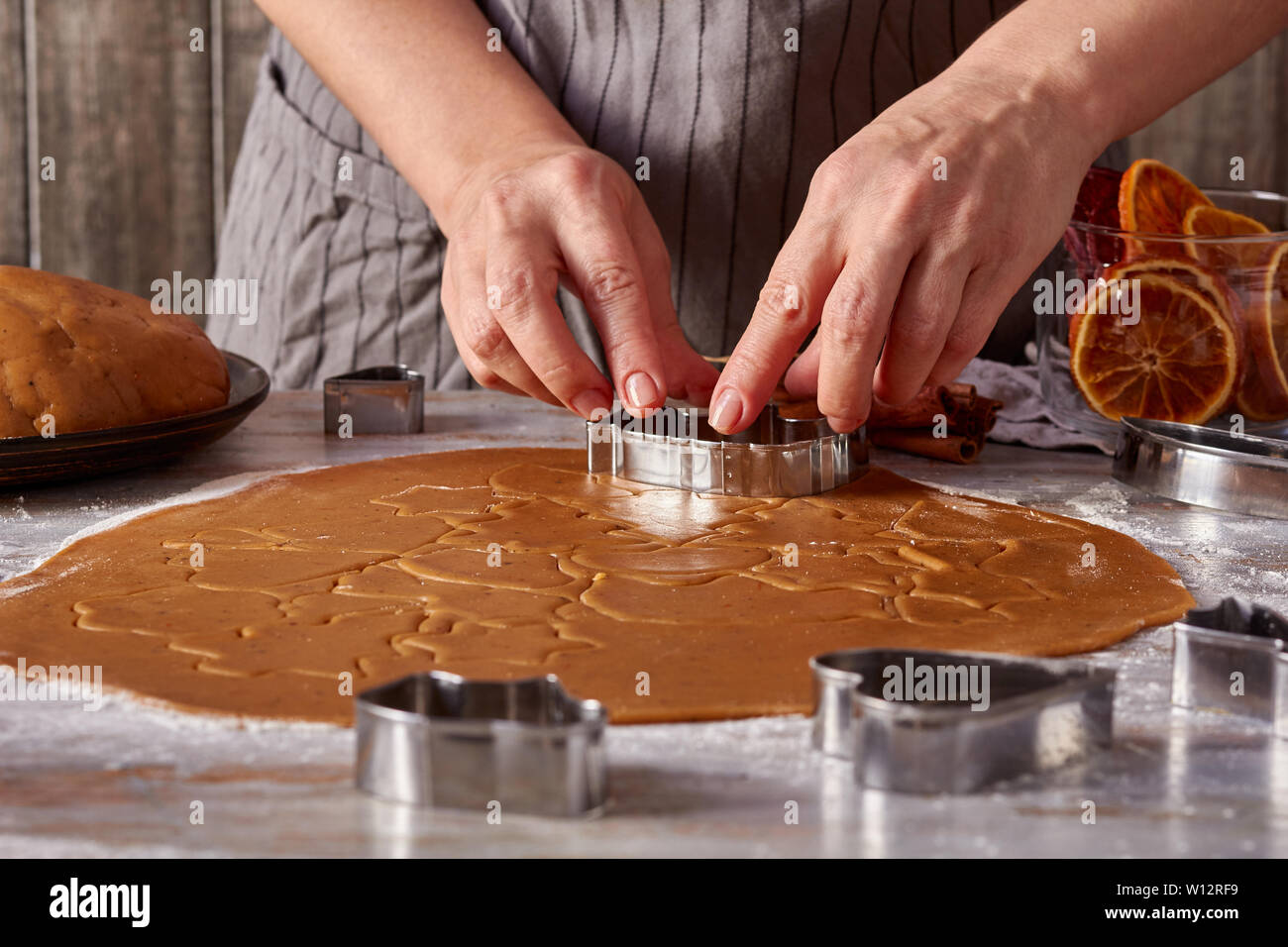 Woman's hands make gingerbread cookies shapes on table Stock Photo - Alamy