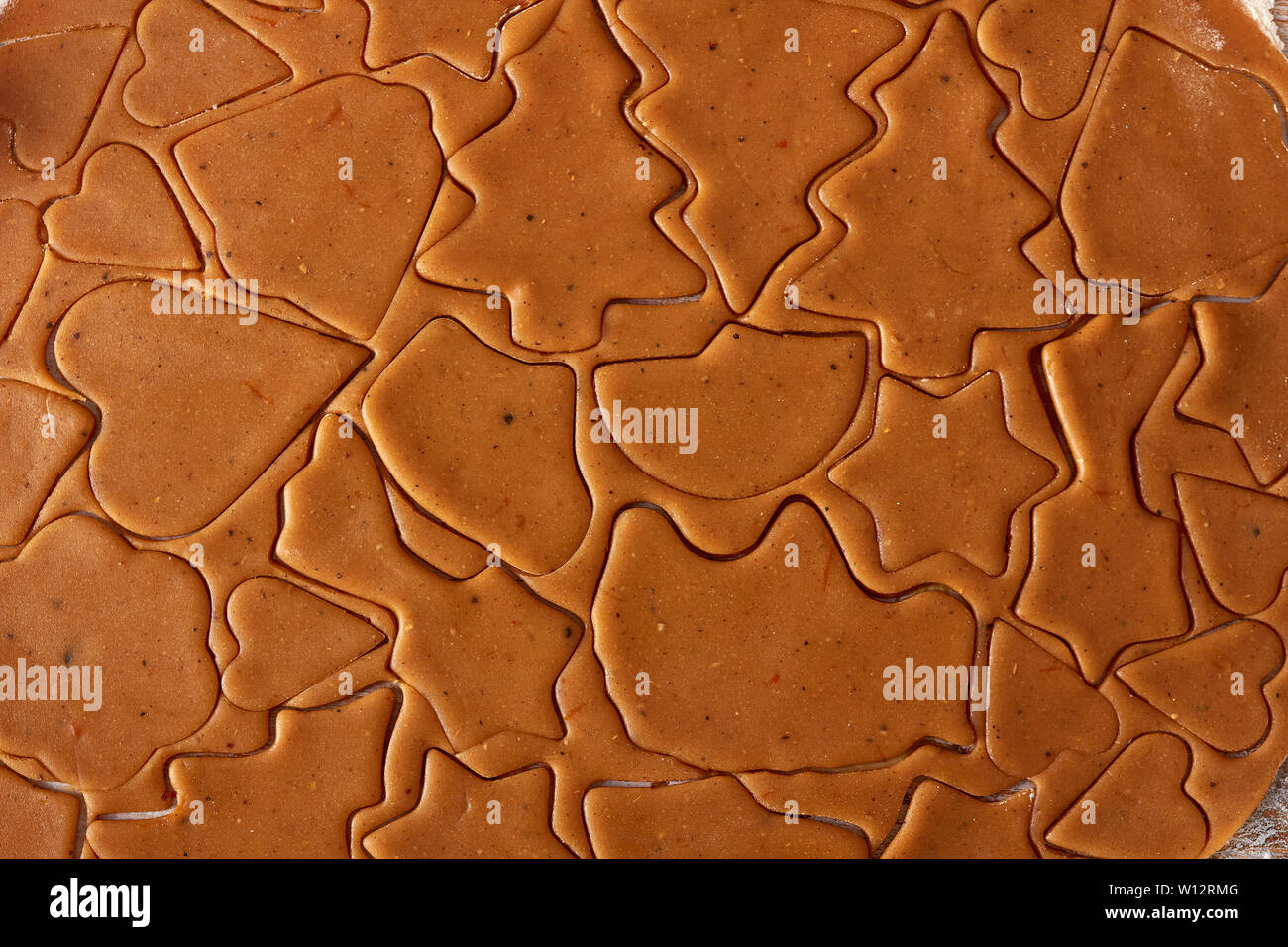 Raw gingerbread dough cookies shapes as background Stock Photo - Alamy